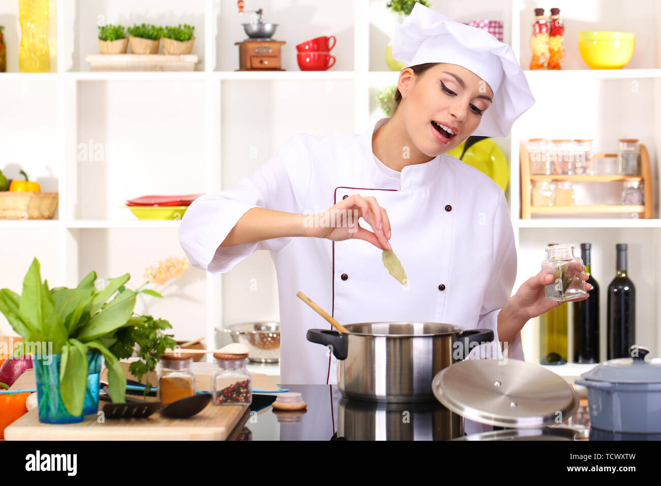 Young woman chef cooking in kitchen Stock Photo - Alamy