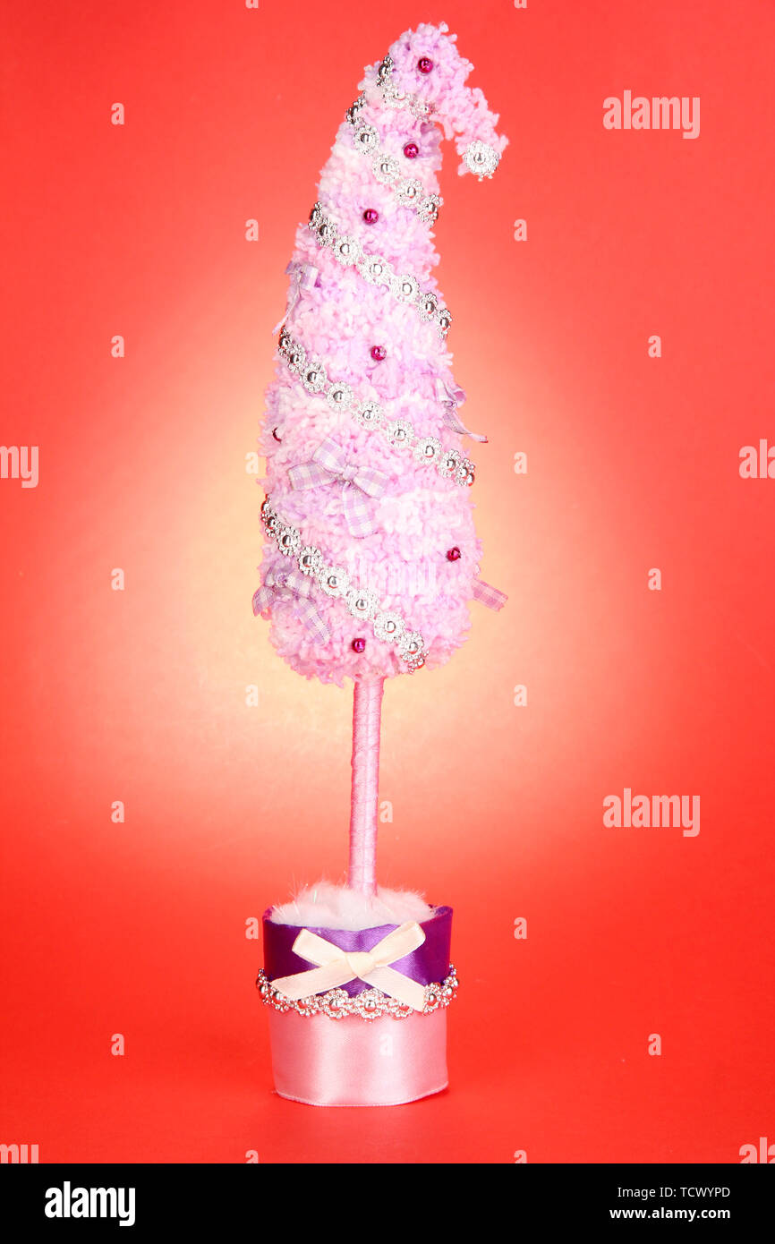 Christmas tree with curved tip on red background Stock Photo - Alamy