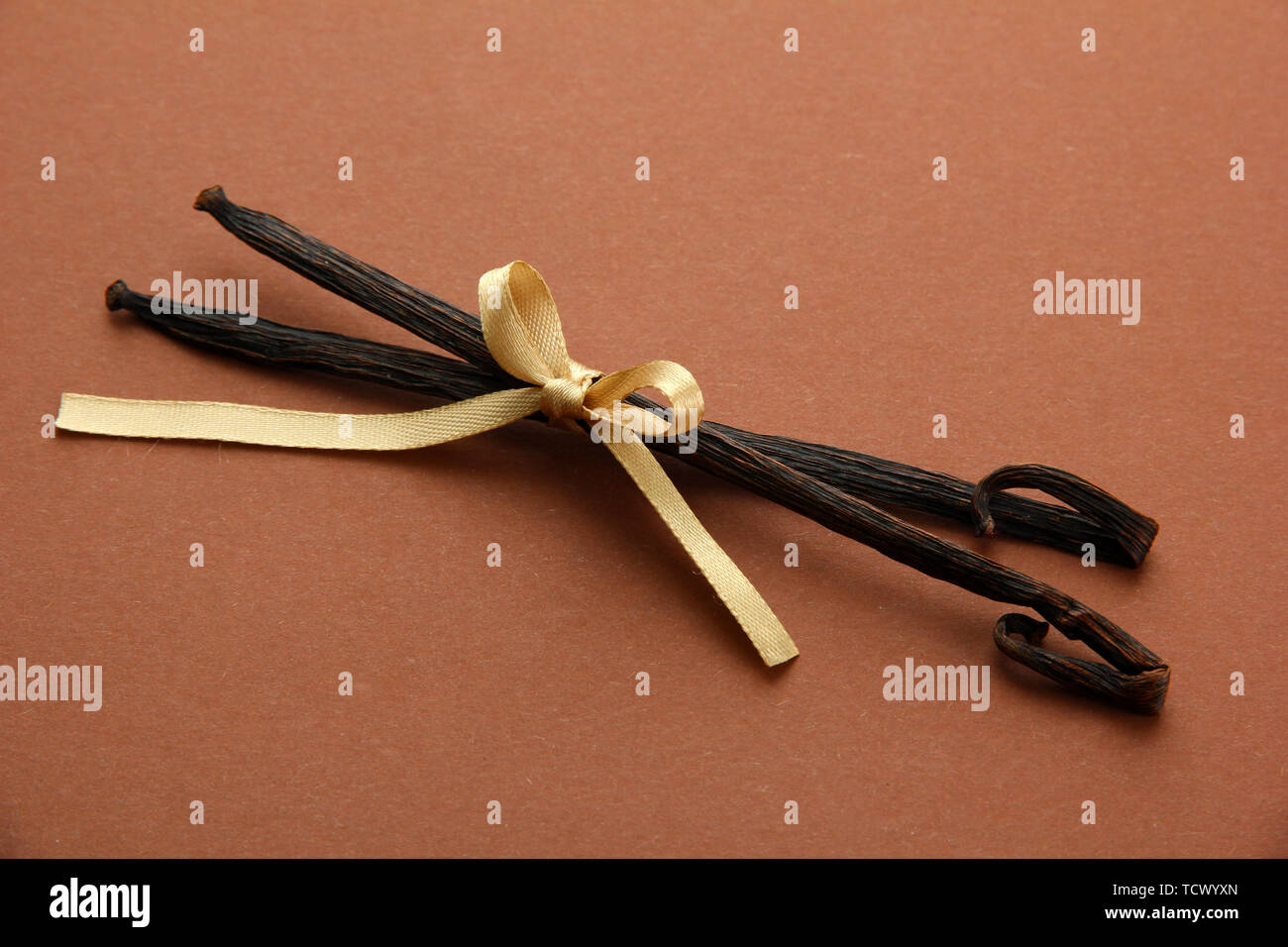 Vanilla pods on brown background Stock Photo - Alamy