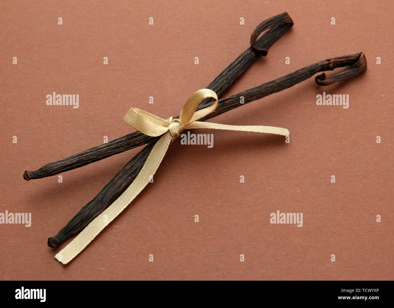Vanilla pods on brown background Stock Photo - Alamy