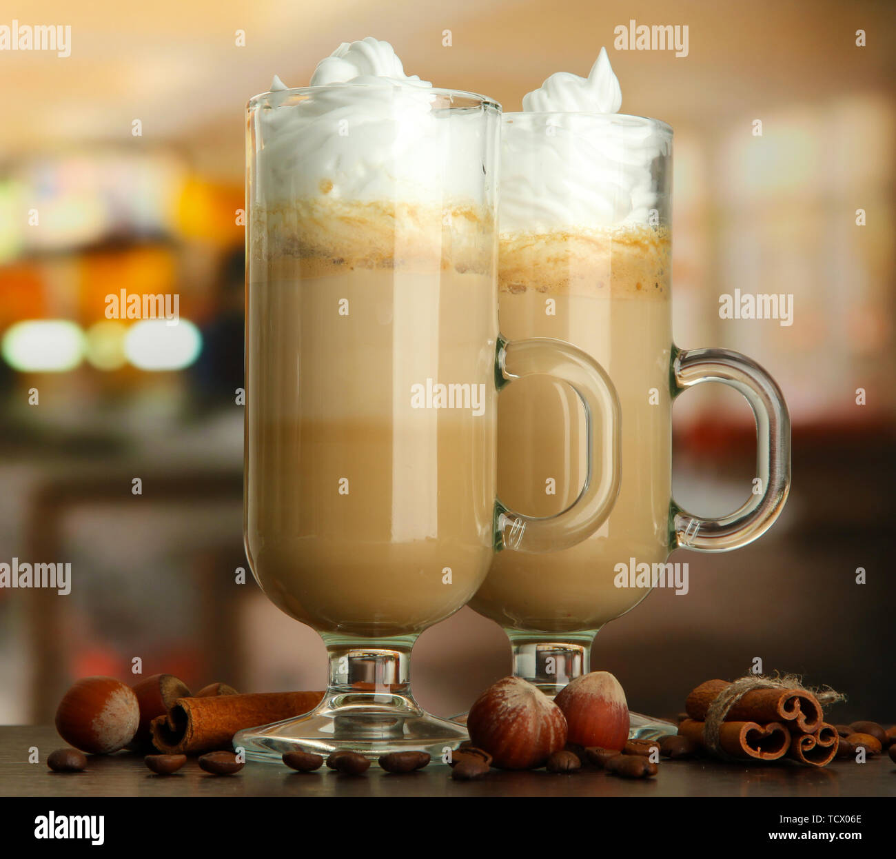 Fragrant coffee latte in glasses cups with spices, on table in cafe ...