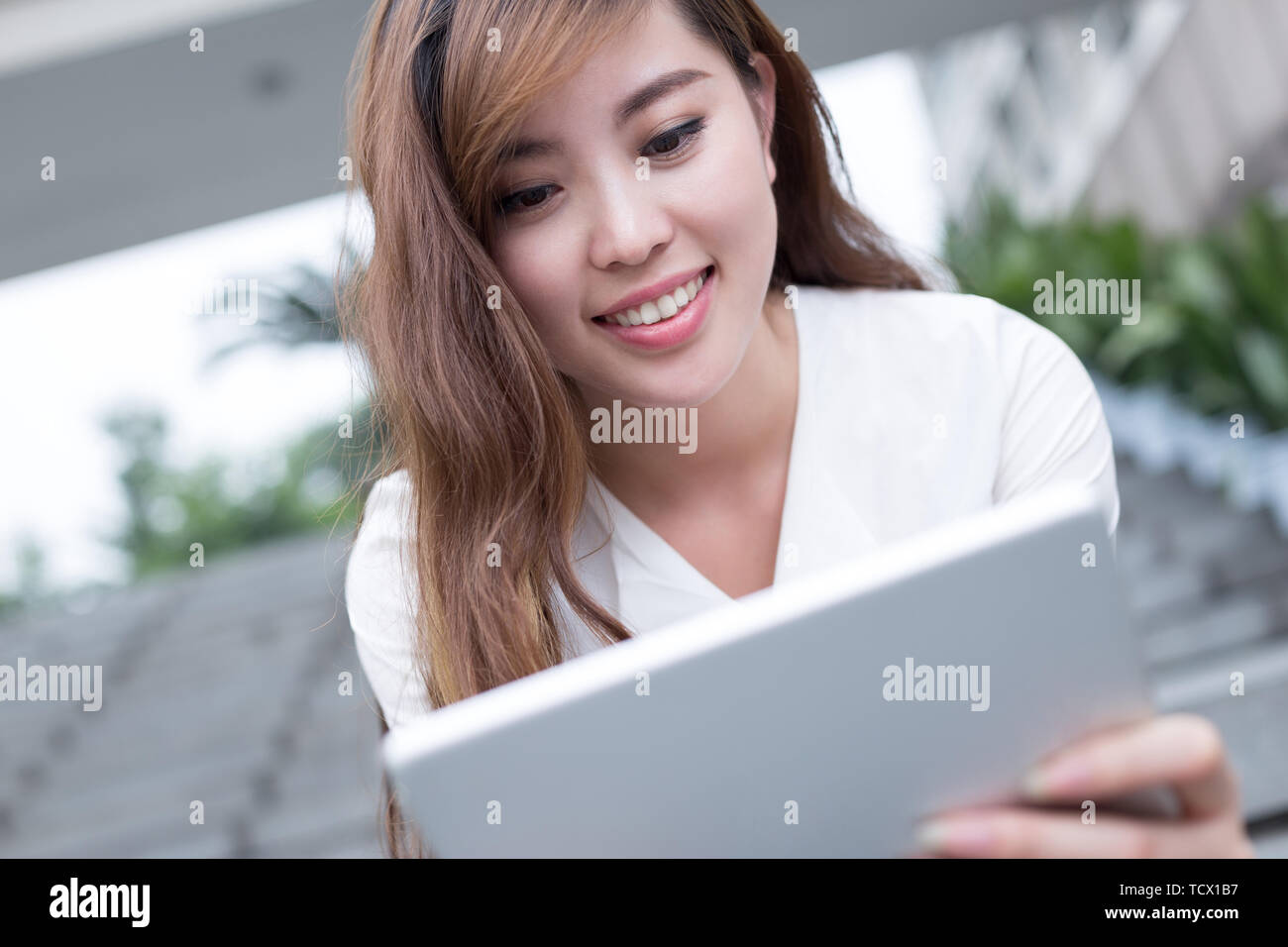 Asian female student using tablet in campus Stock Photo - Alamy