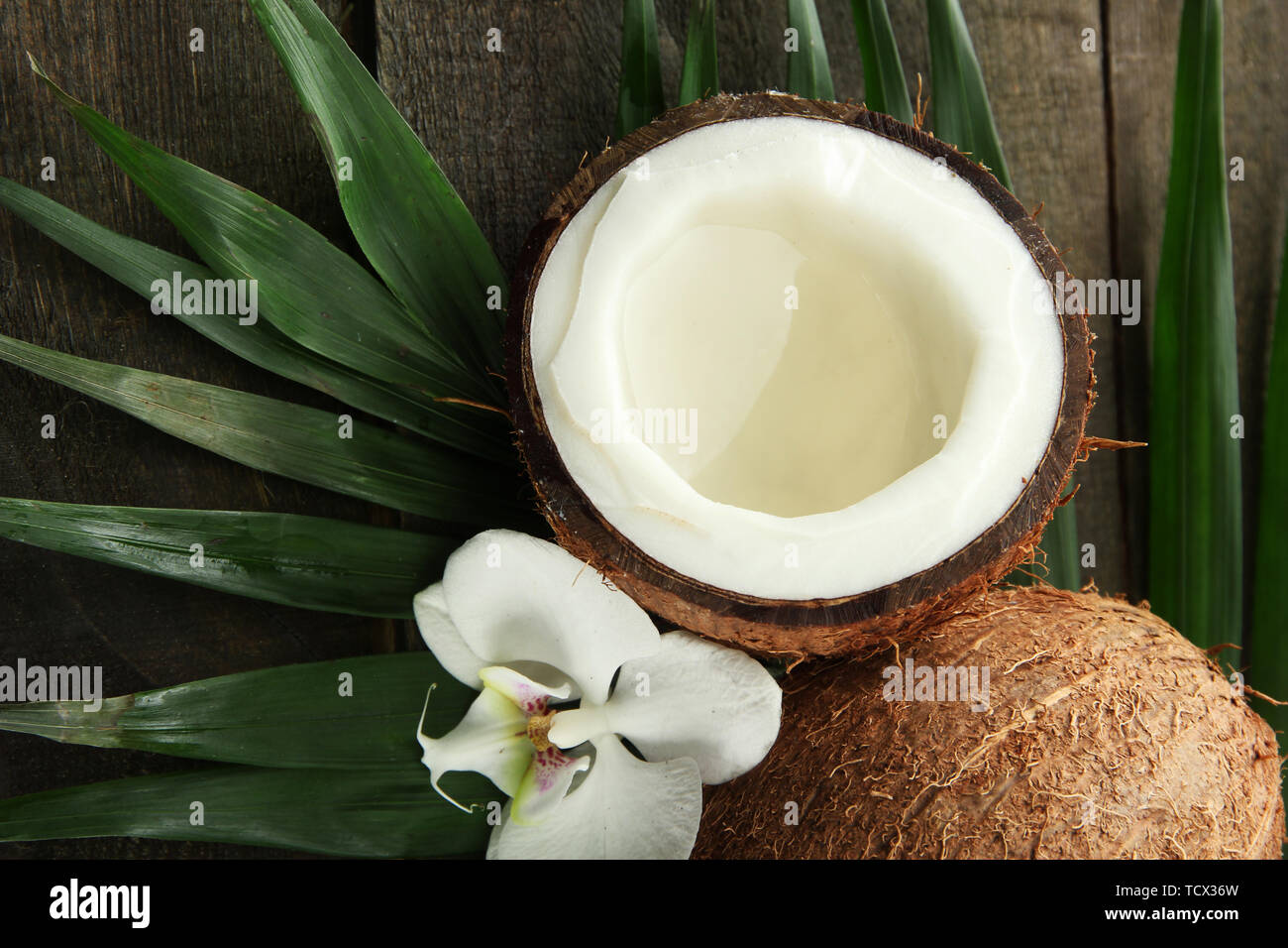 Coconut with leaves and flower, on grey wooden background Stock Photo ...