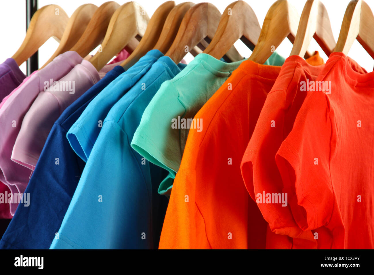 Choice of clothes of different colors on wooden hangers, isolated on ...