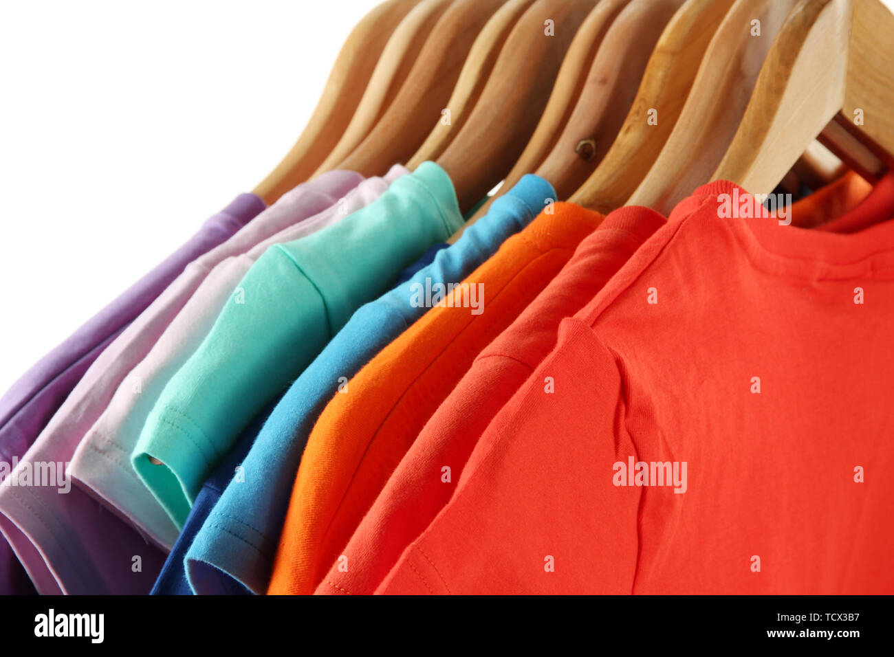 Choice of clothes of different colors on wooden hangers, isolated on ...