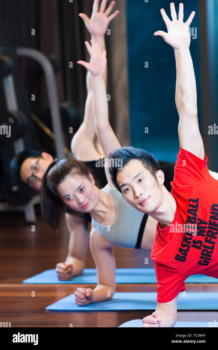 young asian people doing yoga in modern gym Stock Photo - Alamy