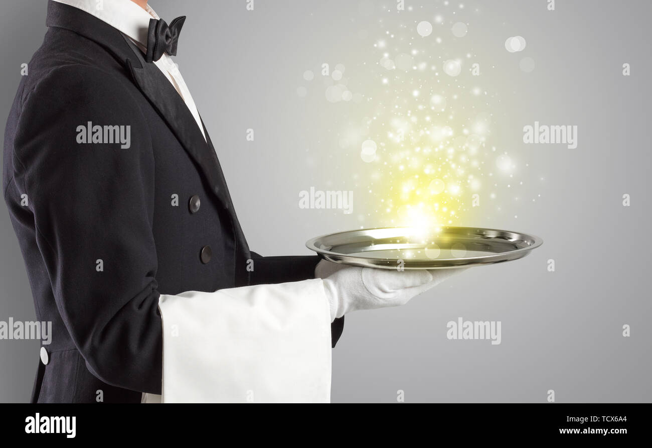Elegant young waiter serving mysterious light on tray Stock Photo - Alamy