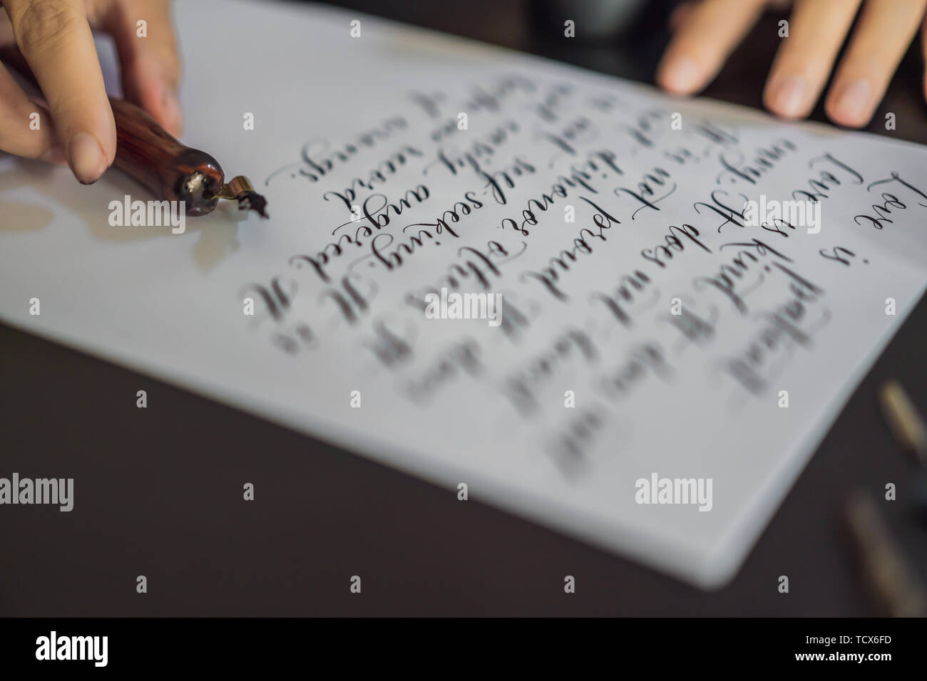 Calligrapher hands writes phrase on white paper. Bible phrase about ...