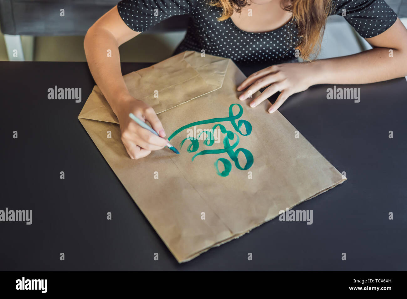Go green. Calligrapher Young Woman writes phrase on white paper ...