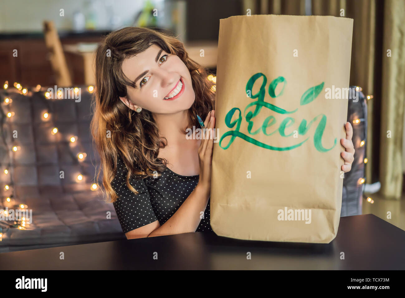 Go green. Calligrapher Young Woman writes phrase on white paper ...