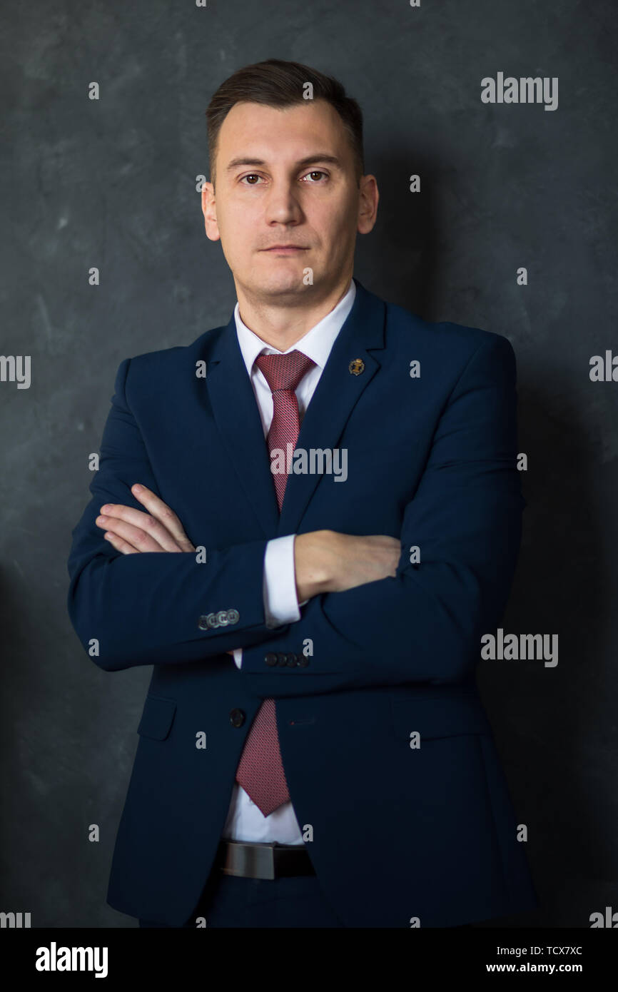 Portrait of young intelligent man lawyer standing with crossed arms in ...