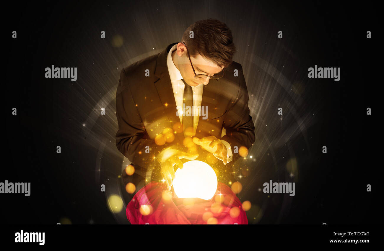 Gorgeous businessman sitting with sparkling magic ball in his lap Stock ...