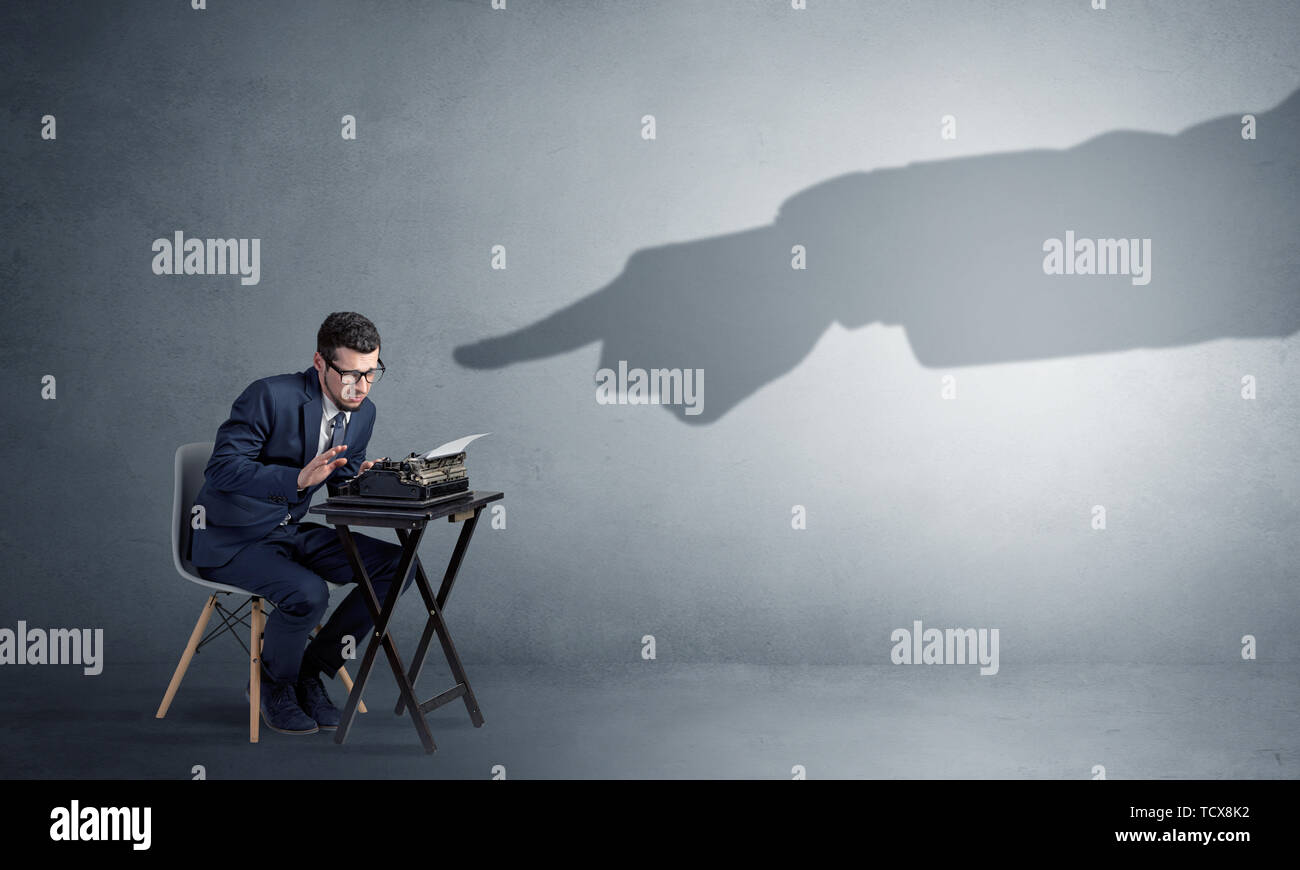 Shadow hand pointing at a small afraid worker Stock Photo - Alamy