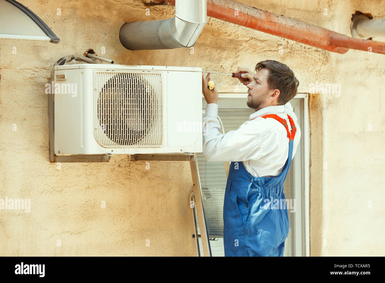 Maintenance guy on air conditioning hi-res stock photography and images ...