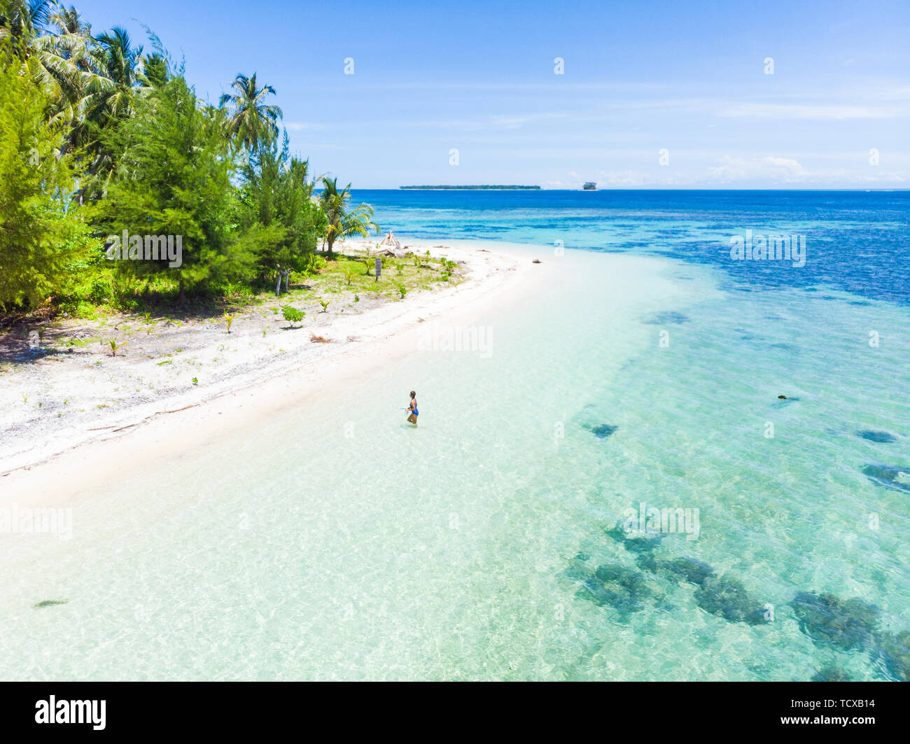 Aerial: Woman getting out of caribbean sea turquoise water tropical ...