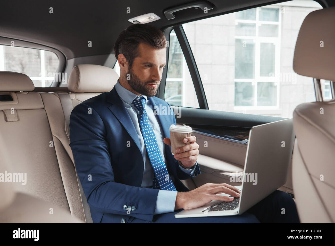 Focused on work. Busy young businessman in formal wear working on ...