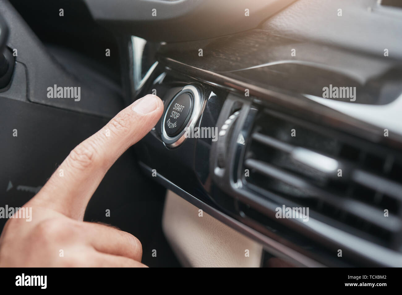 Engine starting. Cropped image of a hand pushing on the start and stop ...