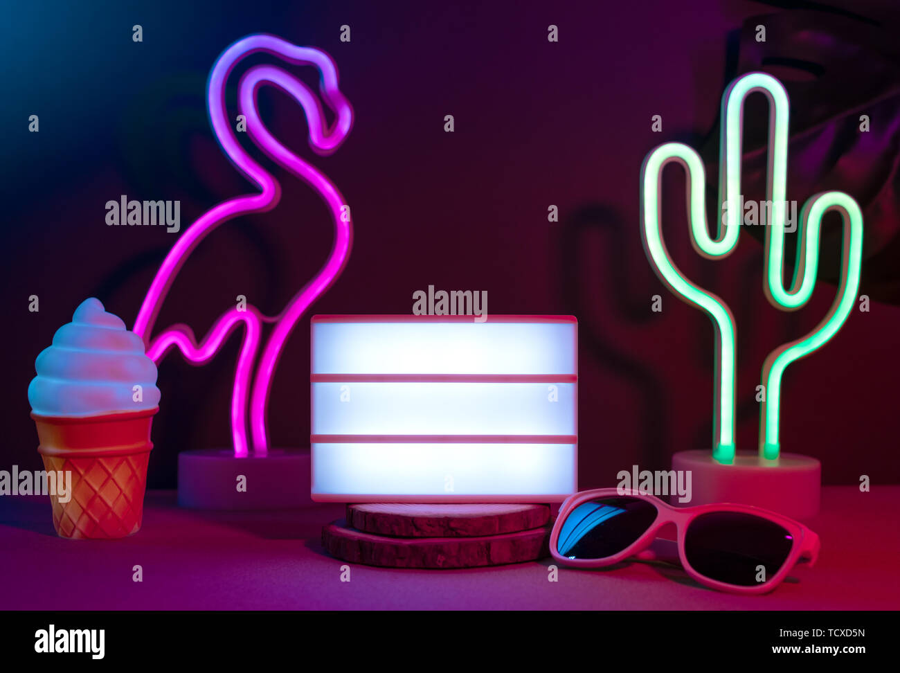 Summer items with flamingo, cactus, sunglasses and blank light box with ...