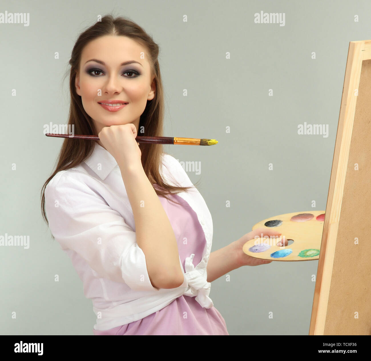 beautiful young woman painter at work, on grey background Stock Photo ...