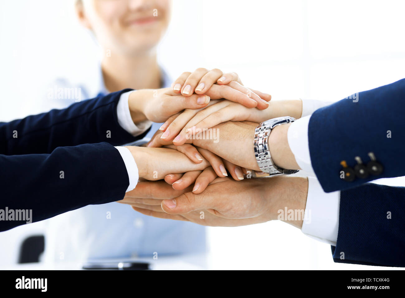 Business team showing unity with their hands together. Group of people joining hands and ...