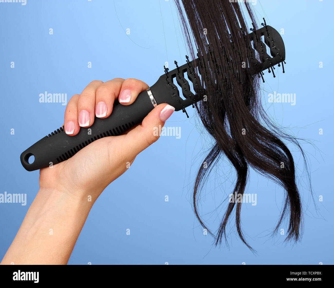 Dark curls brushing comb on color background Stock Photo - Alamy