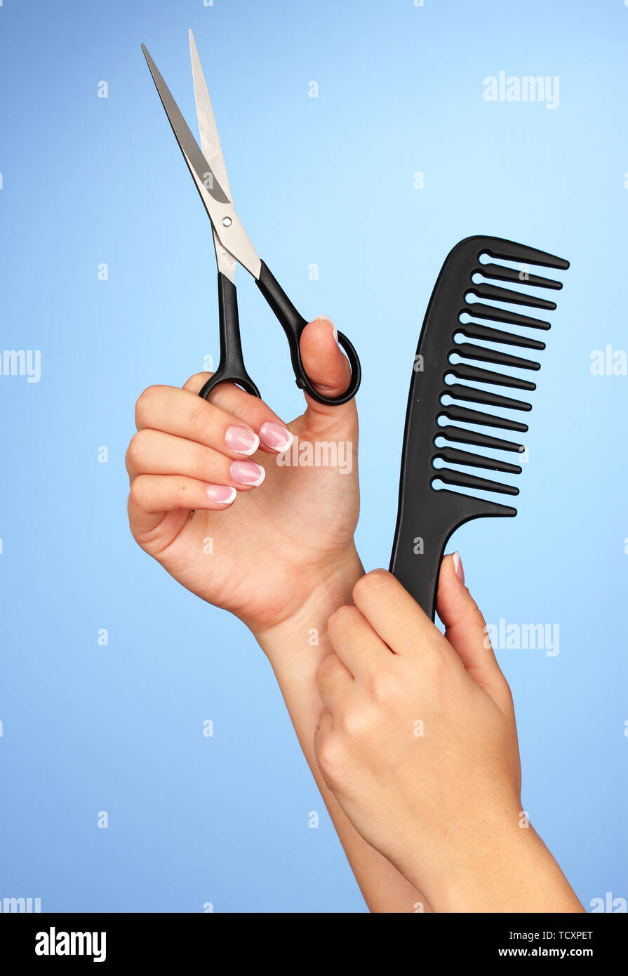 Color comb and scissors in female hand on color background Stock Photo ...