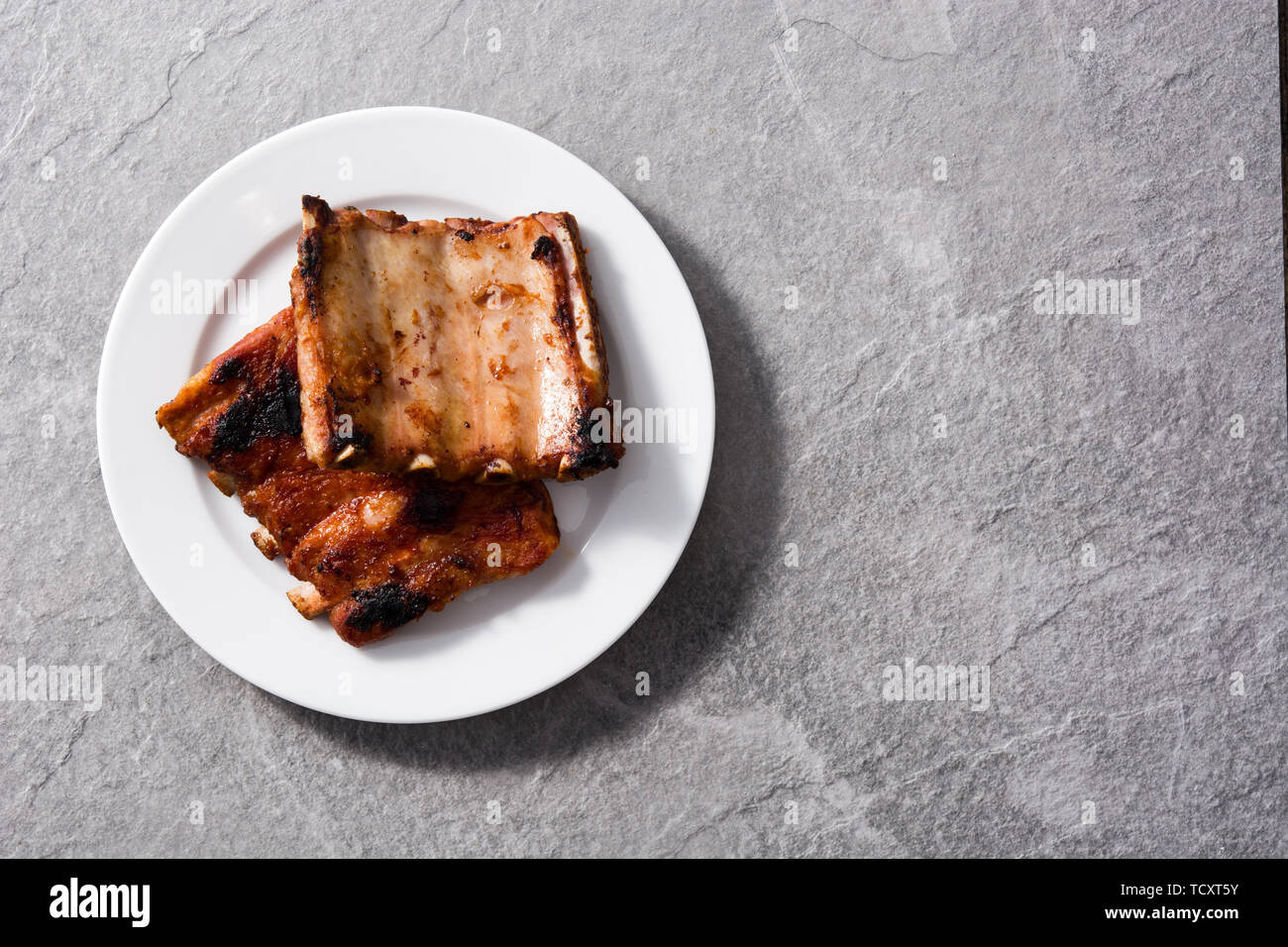 Grilled barbecue ribs on gray stone background Stock Photo - Alamy