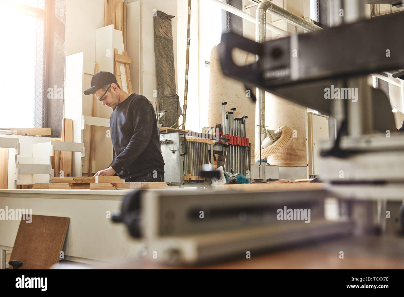 Professional carpenter at work, he is carving wood using a woodworking ...