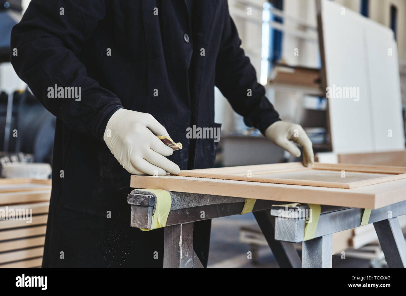 Portrait of woodworker processing the surface of the woodwork at his ...