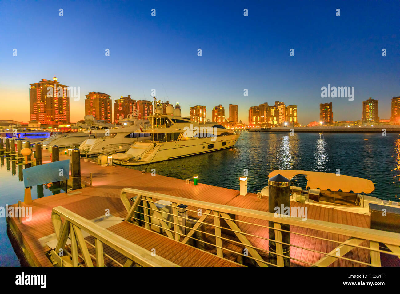 Luxurious yachts and boats docked at Porto Arabia Marina at night. The ...