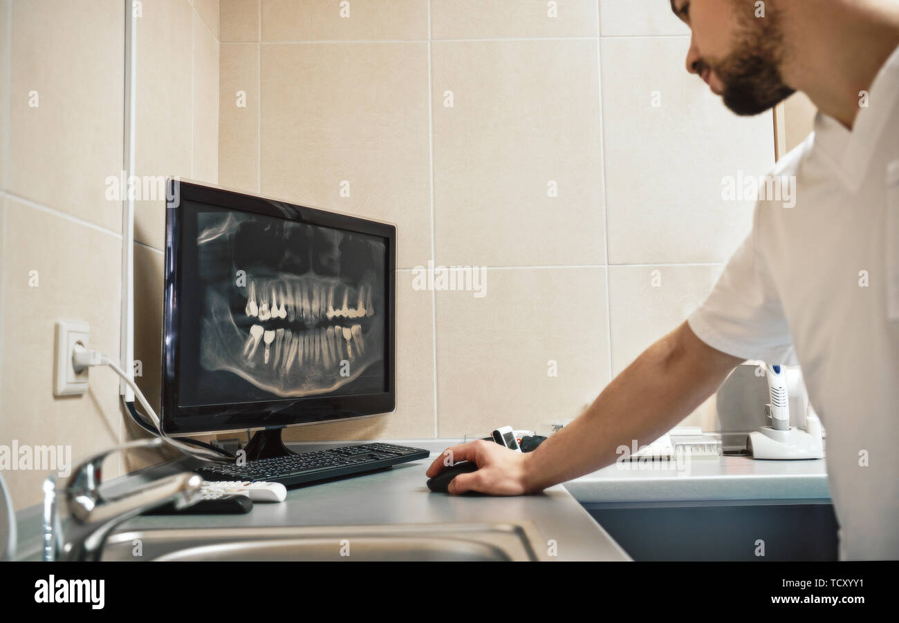 Bearded dental hygienist wearing white uniform is ready to check up ...