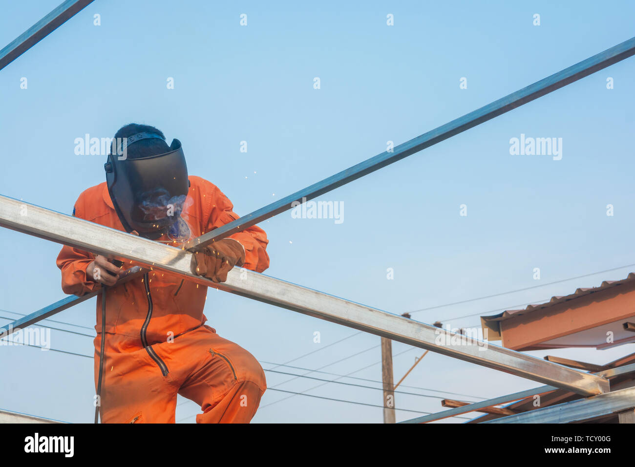 Worker welding in orange work clothes welding For roof truss Stock ...