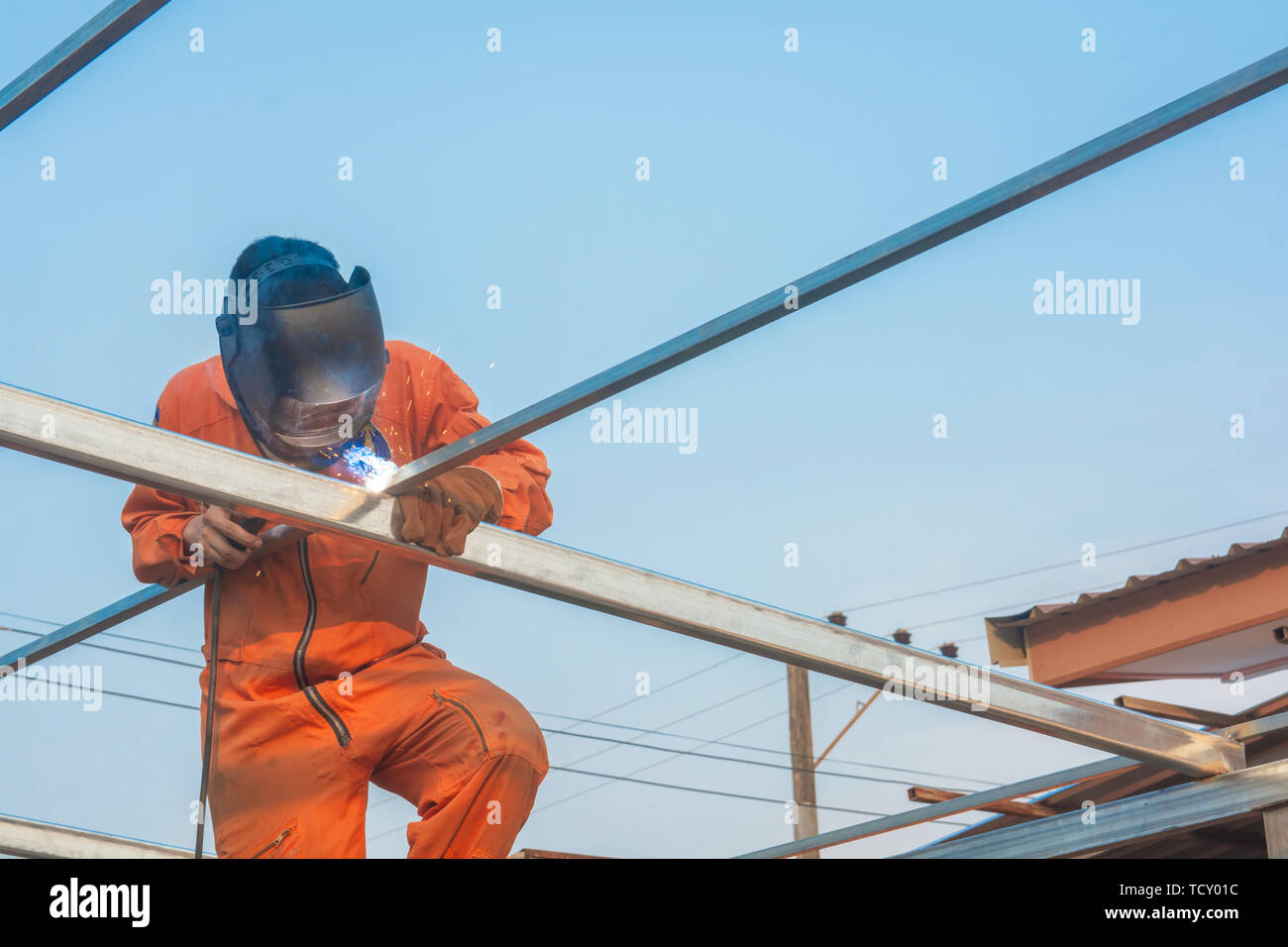 Worker welding in orange work clothes welding For roof truss Stock ...