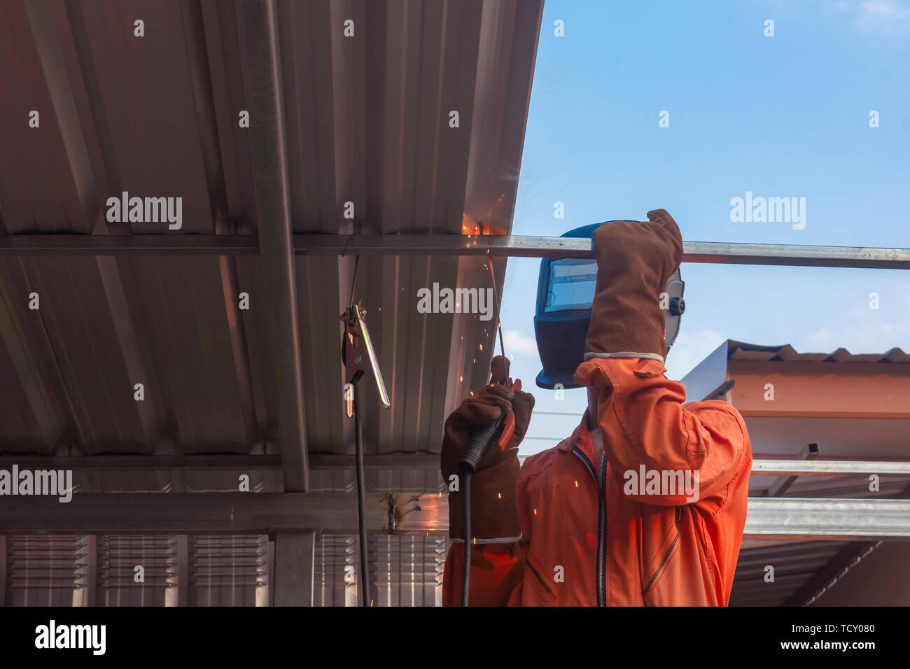 Worker welding in orange work clothes welding For roof truss Stock ...