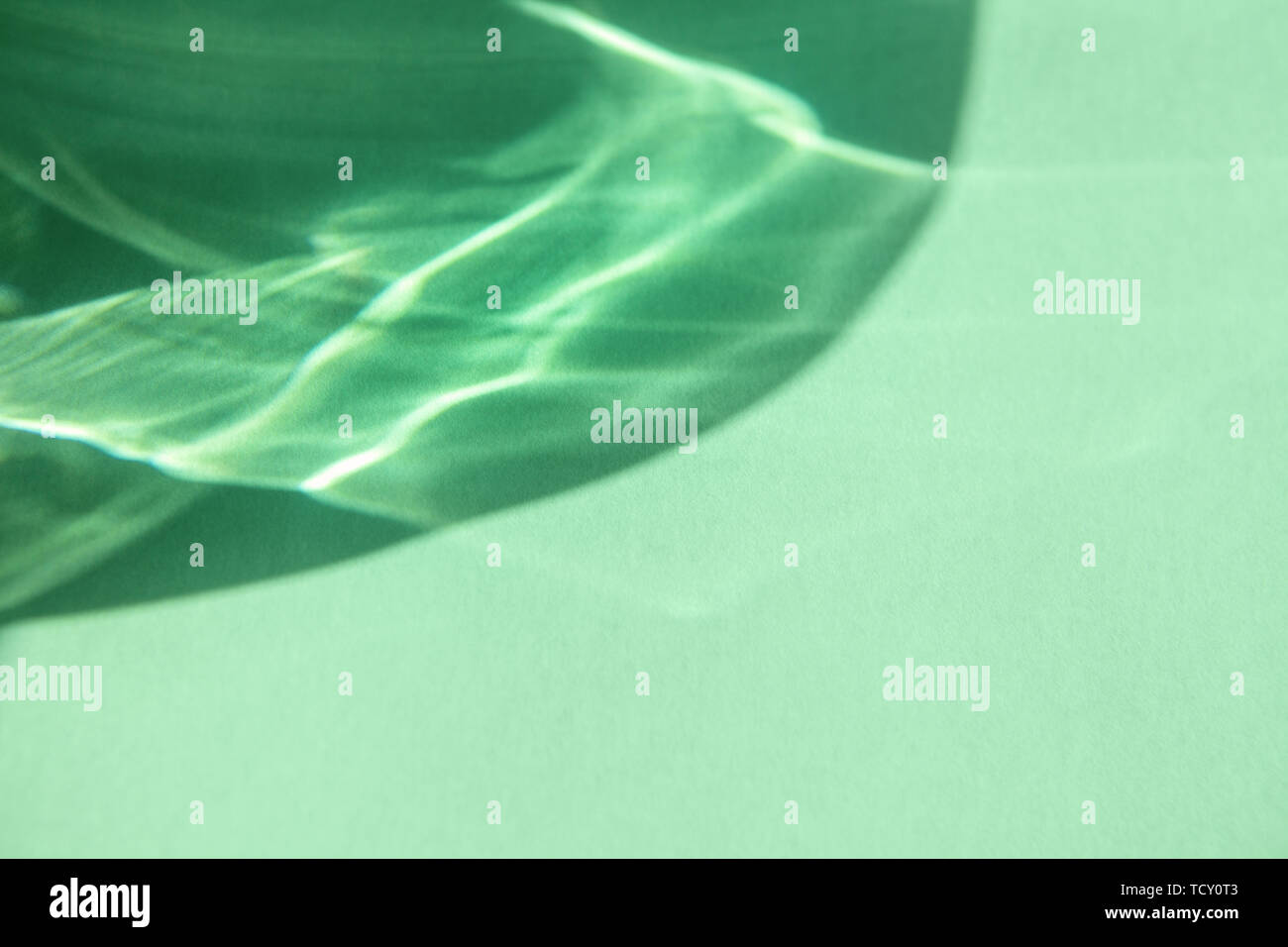 Trendy mint colored abstract background with light and shadows caustic ...