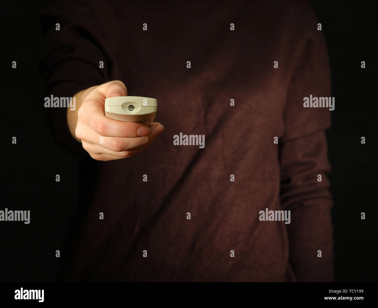 Woman hand holding a TV remote control, on dark background Stock Photo ...