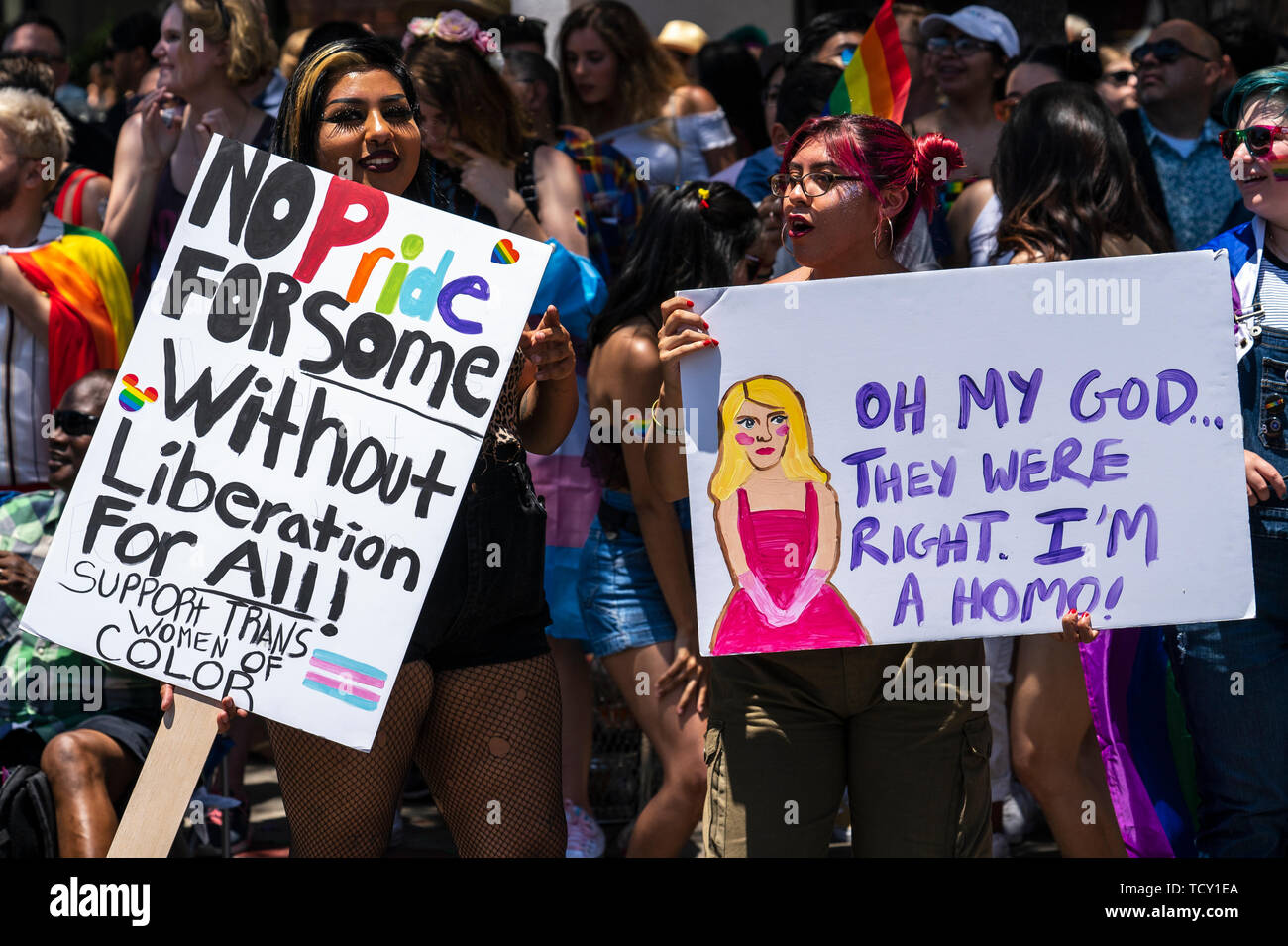 Participants hold placards during the LA Pride Parade in West Hollywood ...