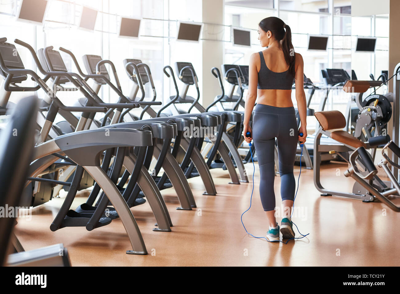 Finishing workout. Back view of short and slim young woman in ...