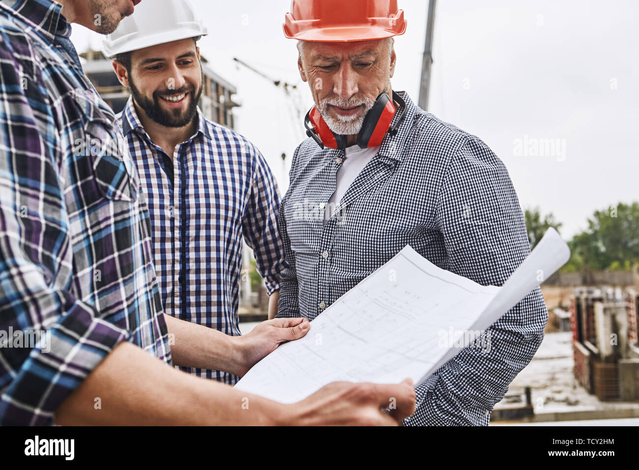 Project discussing. Senior engineer in formal wear and helmet looking ...
