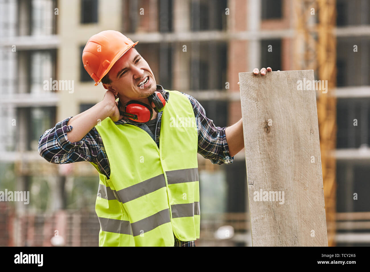 Health insurance. Construction worker in protective helmet feeling neck ...