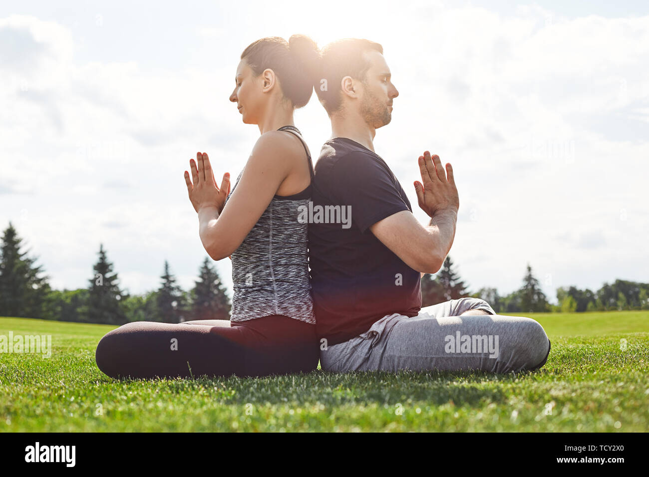 Balance your life. Young couple meditating together while sitting ...