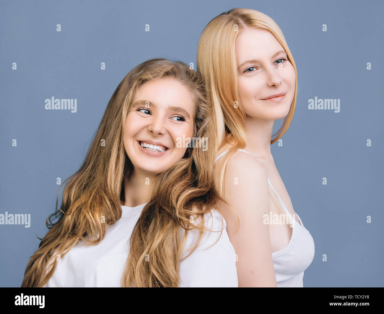 Close-up lifestyle friends portrait Two smiling girls in white T-shirts ...