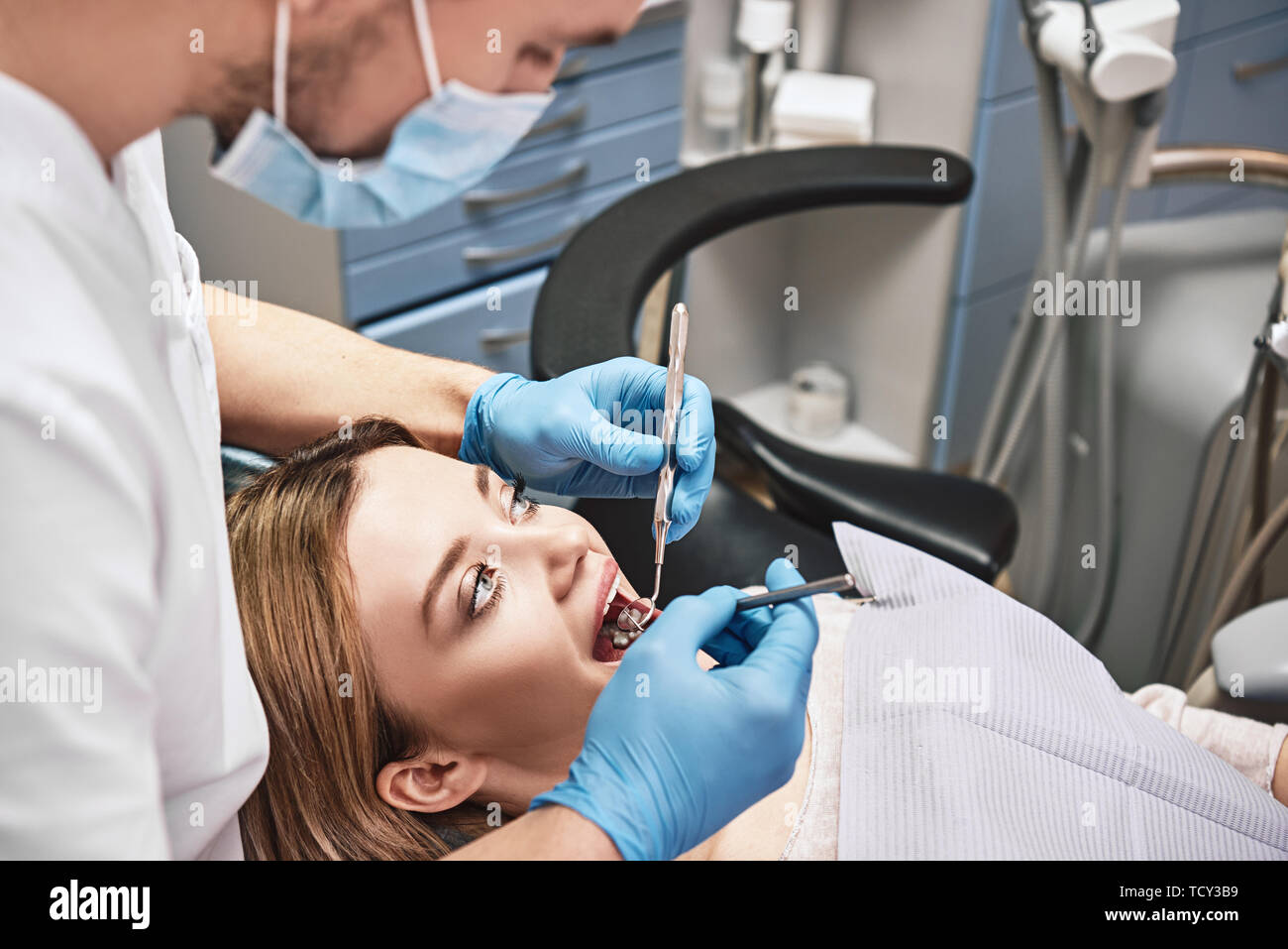 Close-up of blonde woman opening her mouth wide during inspection of ...