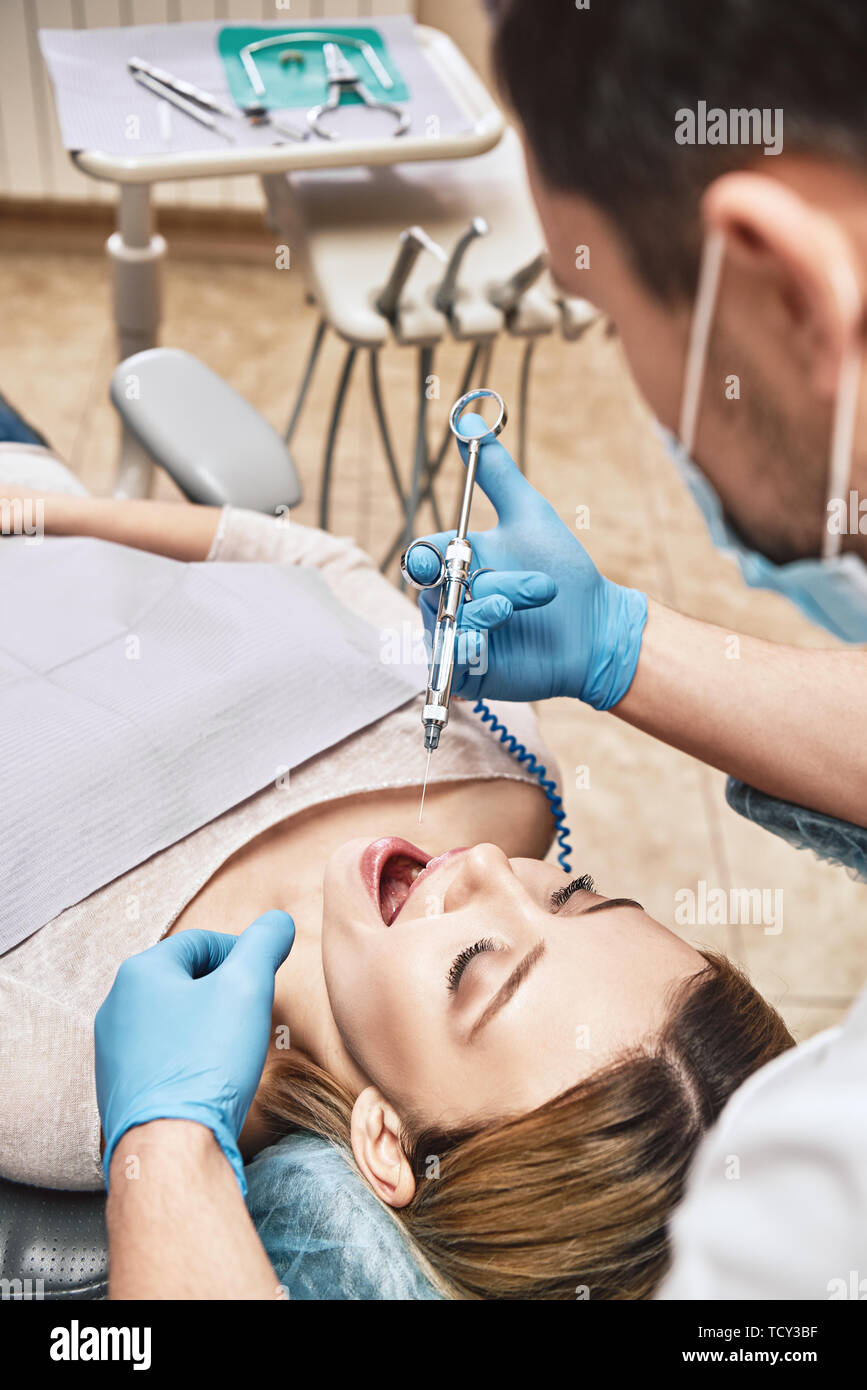 Male doctor with injection. Young dentist injects anesthesia before ...