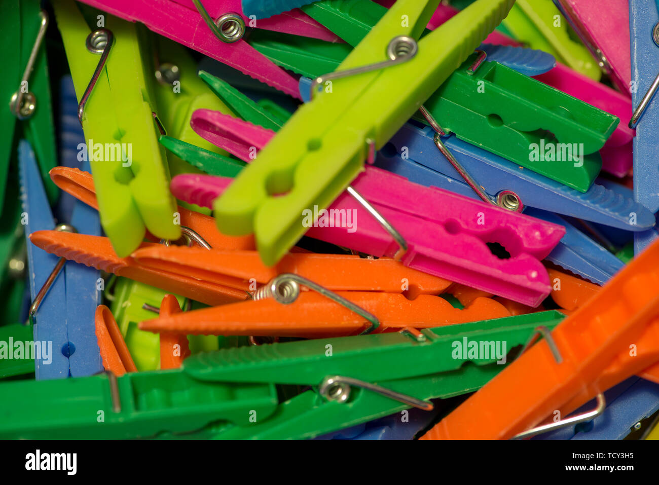 A handful of clothespins hanging clothes of various types of colors ...