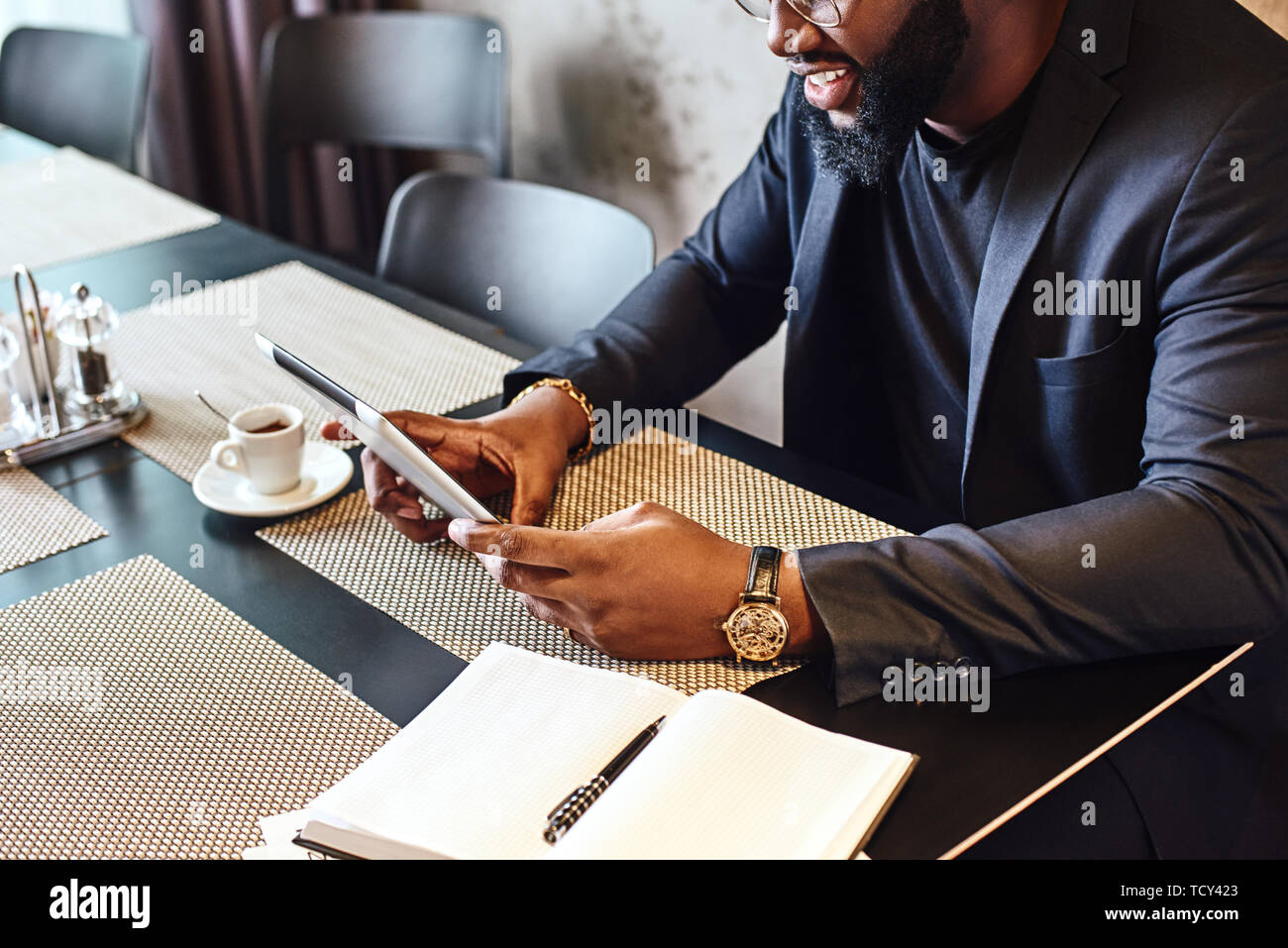 Portrait of focused African-American office manager in dark-blue jacket ...