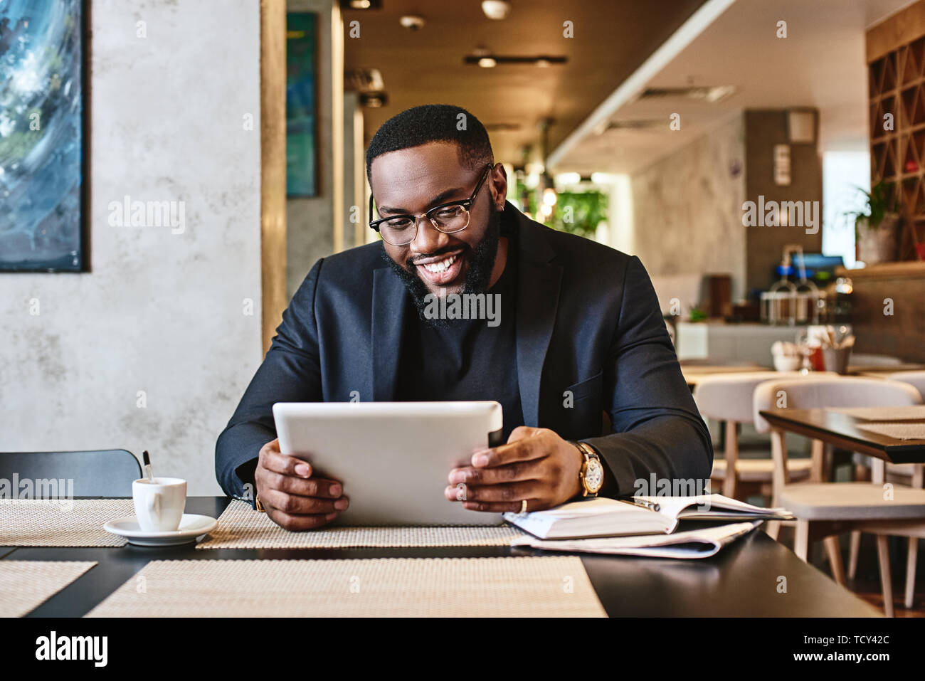Portrait of focused African-American office manager in dark-blue jacket ...