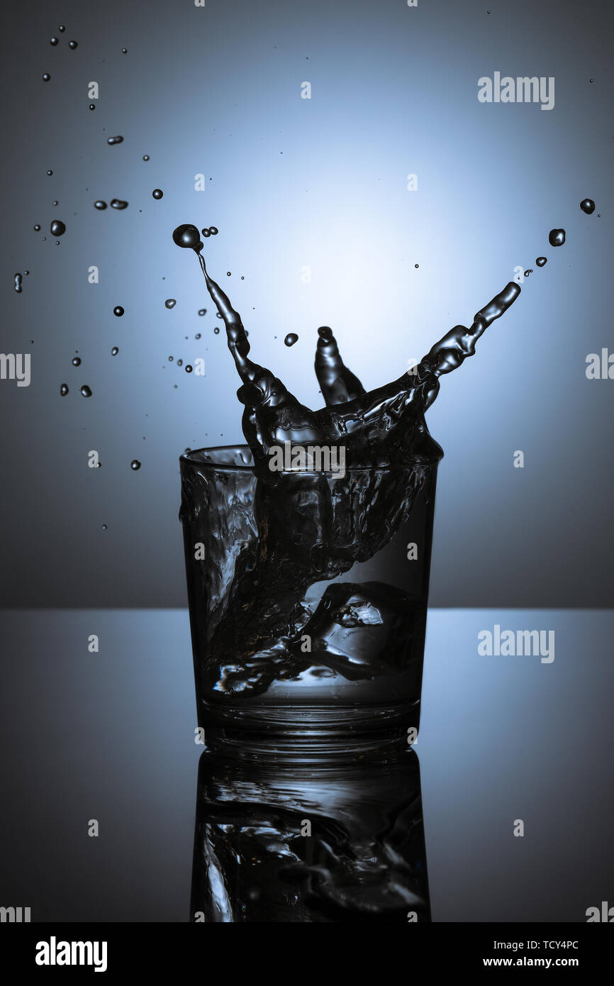 An ice cube splashing into a refreshing drink Stock Photo - Alamy