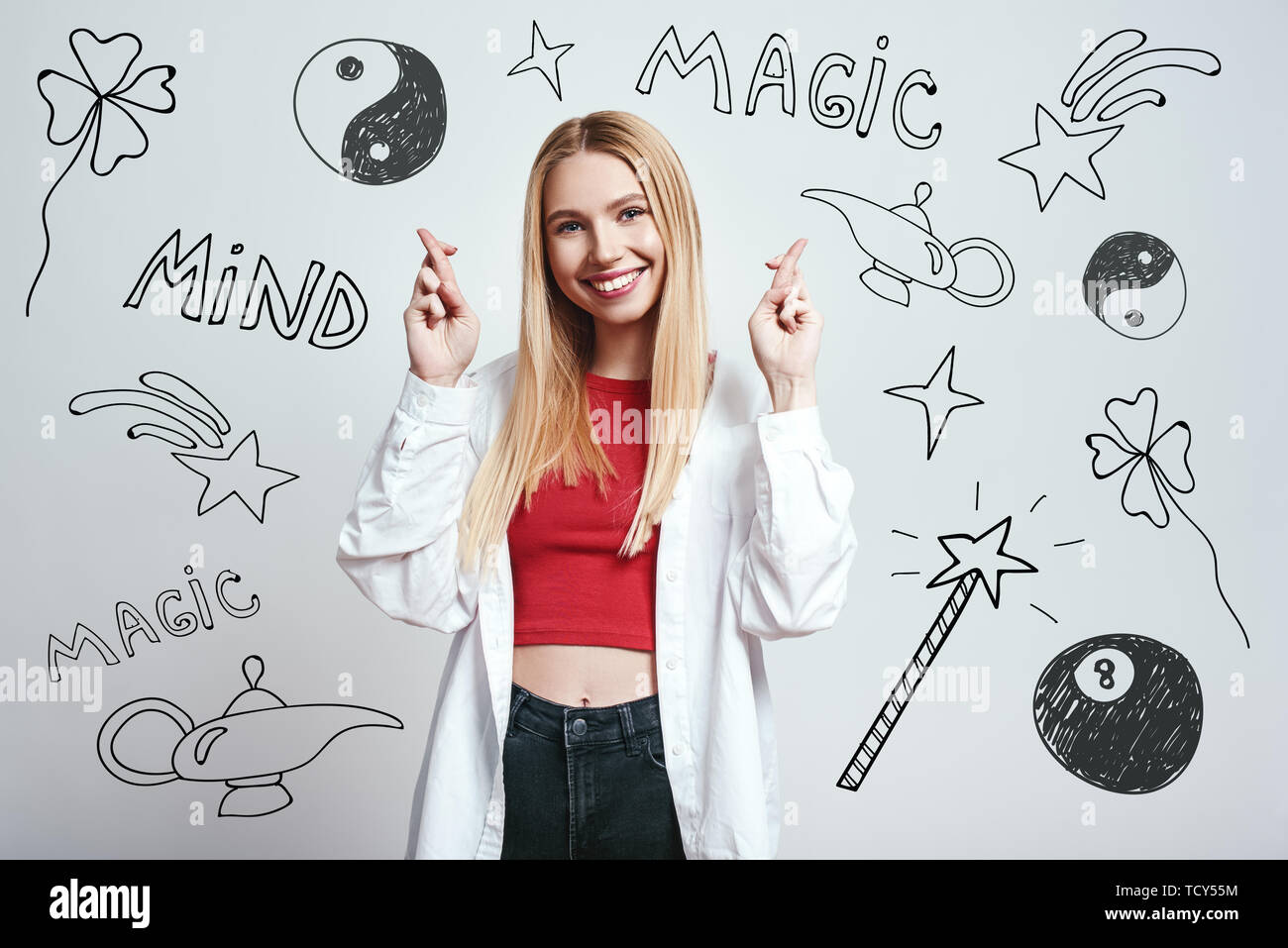 I know magic trick. Smiling young blonde woman in white shirt holding ...