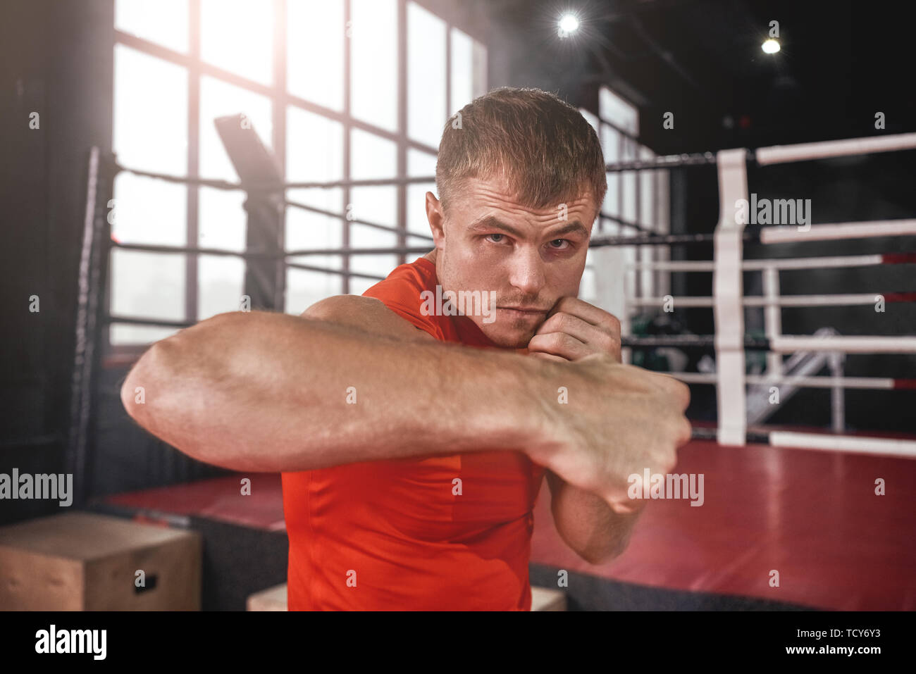 Close-up of focused muscular athlete in sports clothing performing side ...